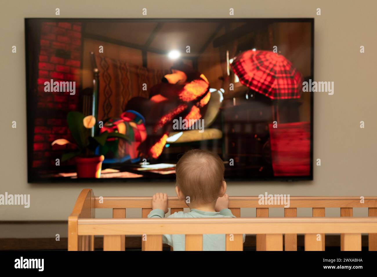 Bright cartoons fascinate a small child when he looks at the screen ...