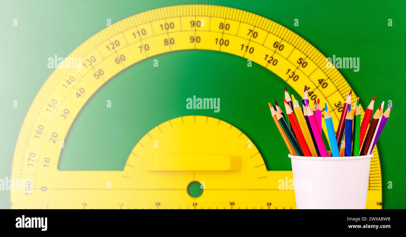 The School concept colored penciil and yellow protractor on green ...