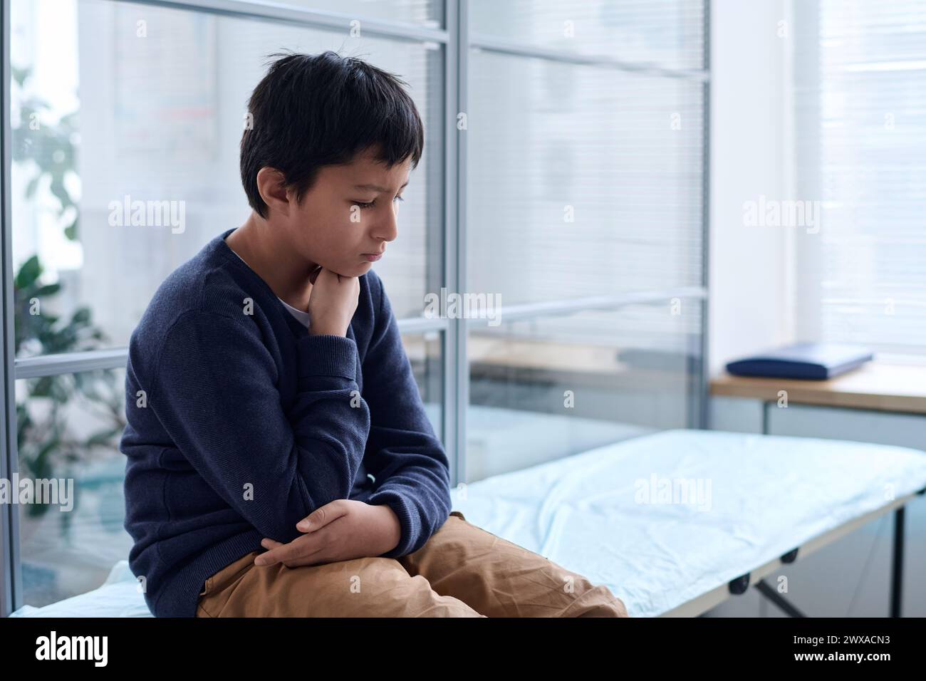 Side view portrait of distressed Middle eastern boy sitting on ...