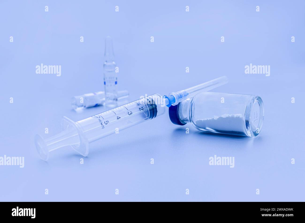 Vaccine in vial and syringe close up on blue background, medical ...
