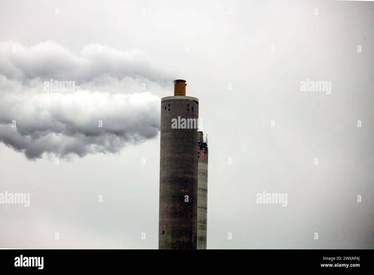 Steam and polluting smoke rises from the chimney of waste incinerator ...
