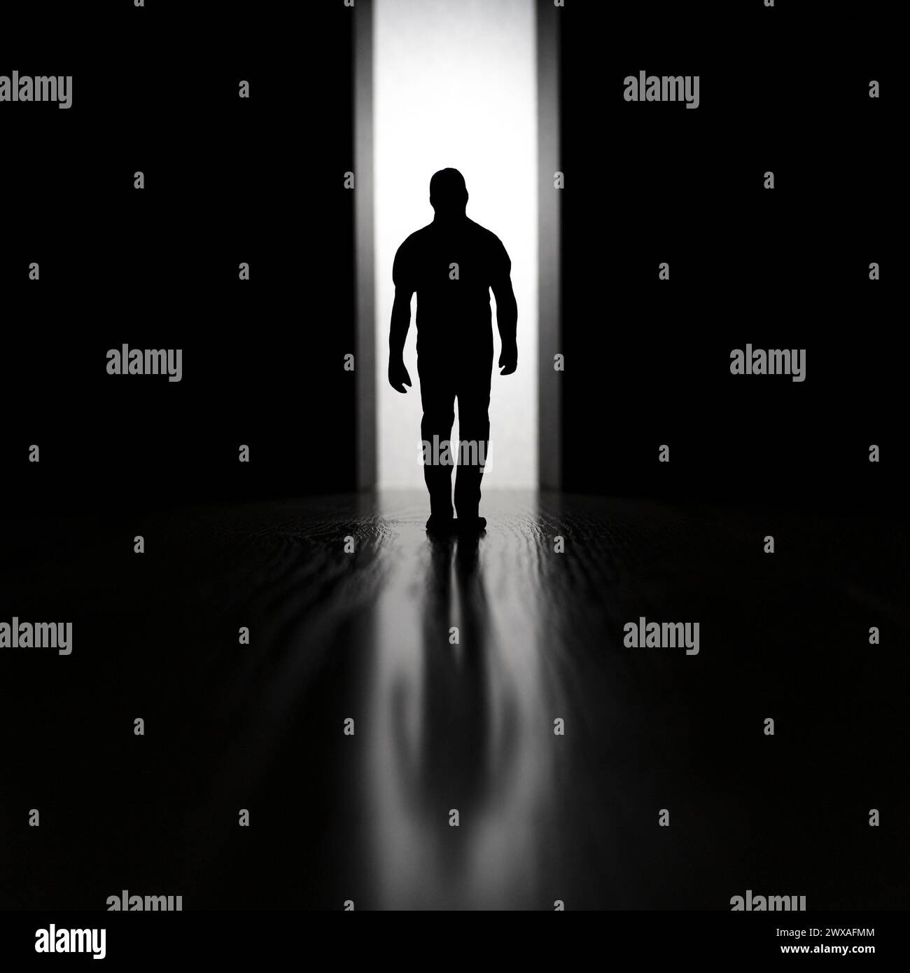 Man getting out of dark room trough bright doorway Stock Photo - Alamy