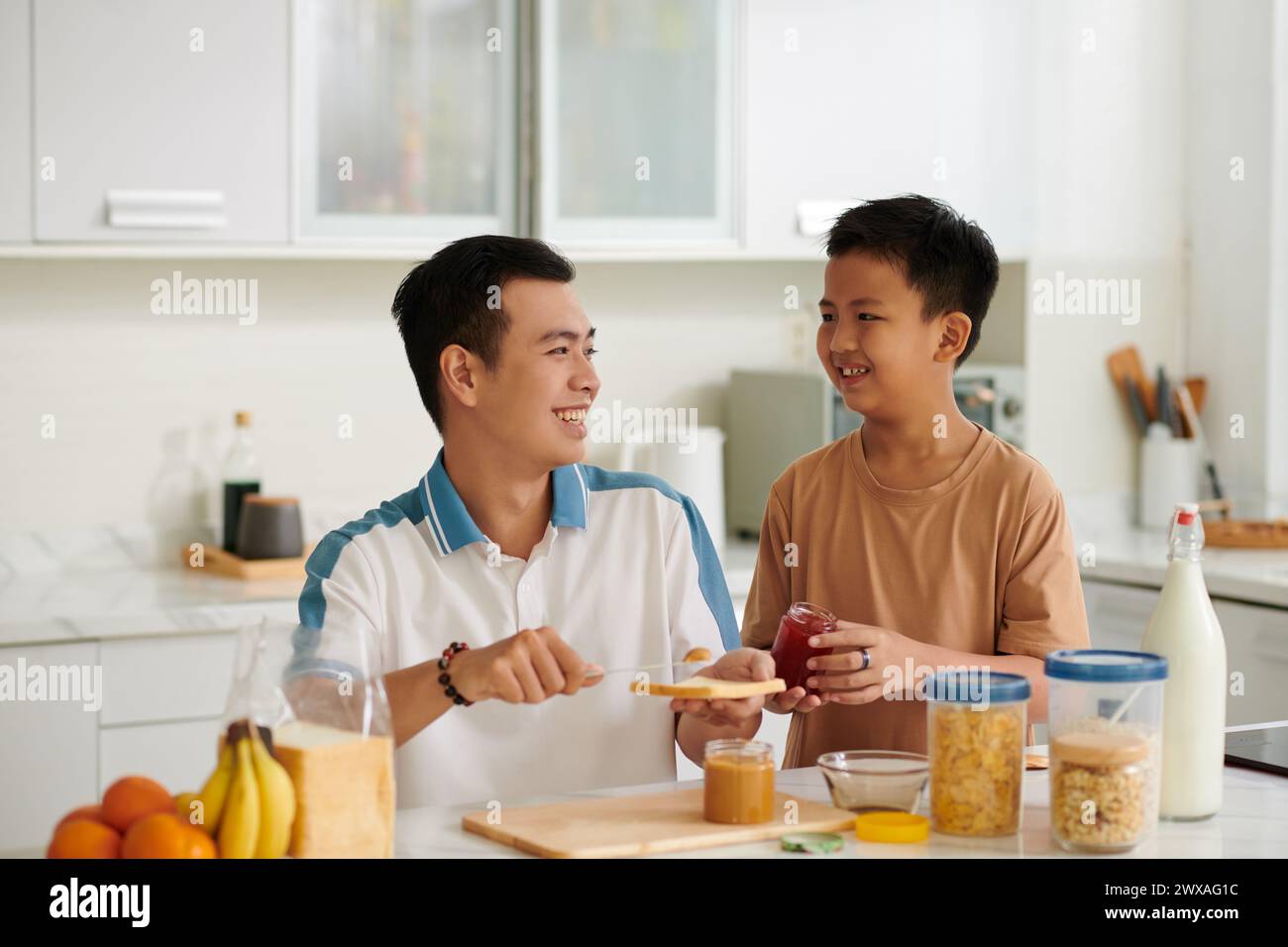 Happy Vietnamese father and son making sandwiches for breakfast Stock ...
