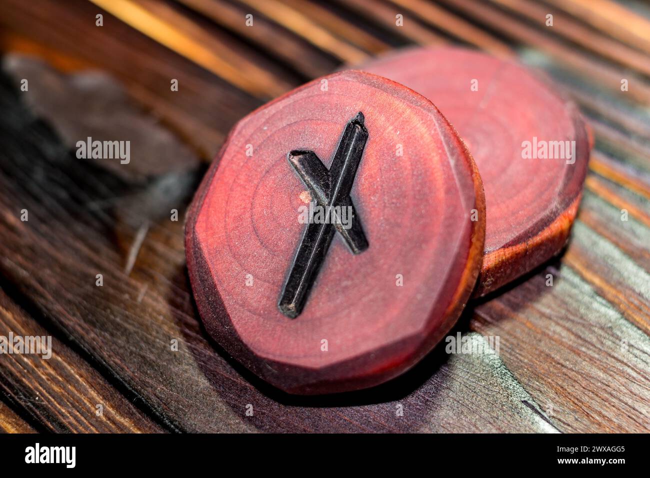 Rune Naudiz red color carved from wood on a wooden background - Elder ...