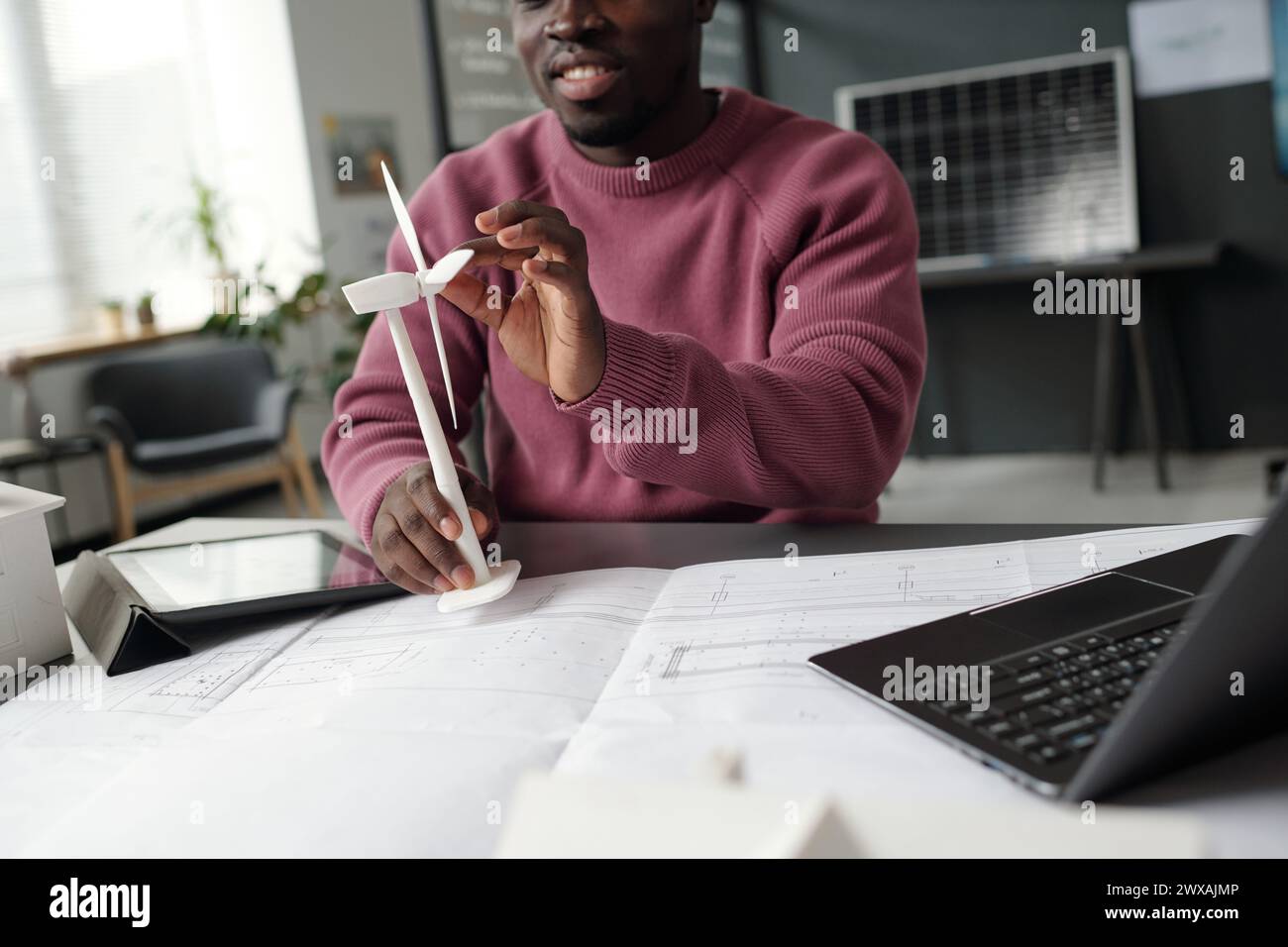 Cropped shot of young modern architect rotating turbine of windmill ...