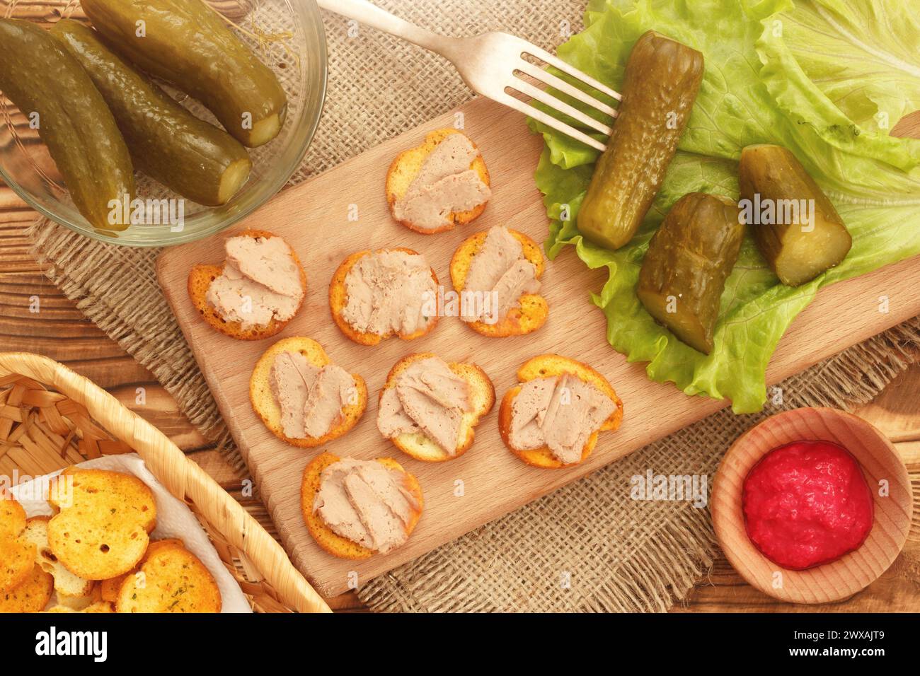 Top View Bruschetta Rusks With Liver Pate And Pickles On Wooden Plate ...