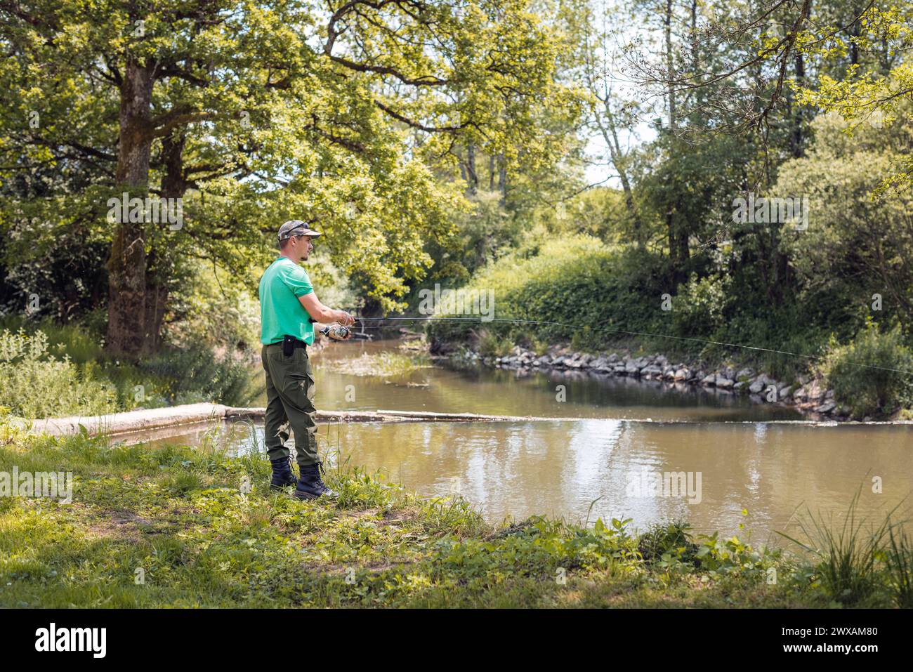 Recreational fisherman at river bank trying to catch a fish. Angler ...