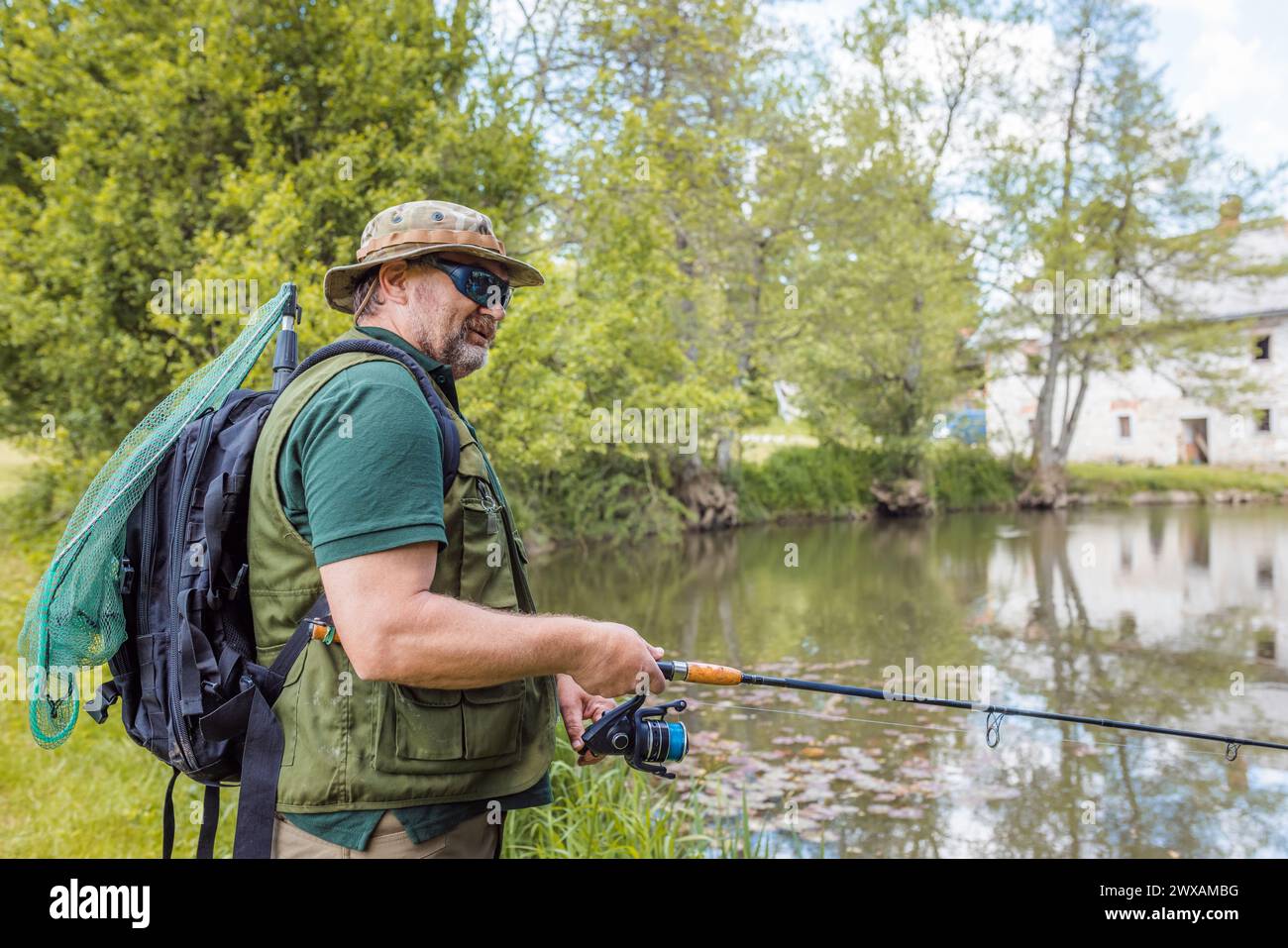 Recreational fisherman at river bank trying to catch a fish. Angler ...