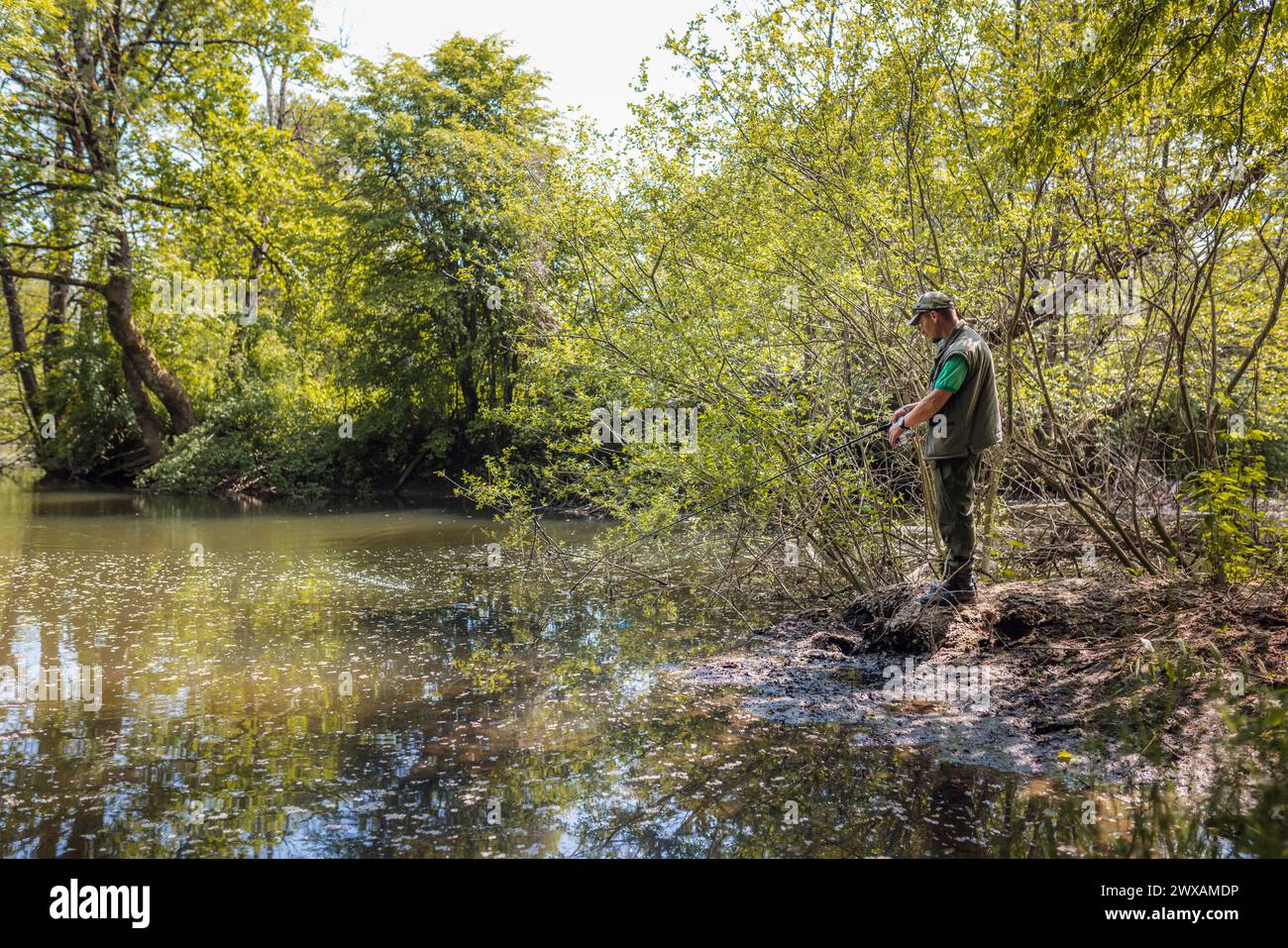 Recreational fisherman at river bank trying to catch a fish. Angler ...
