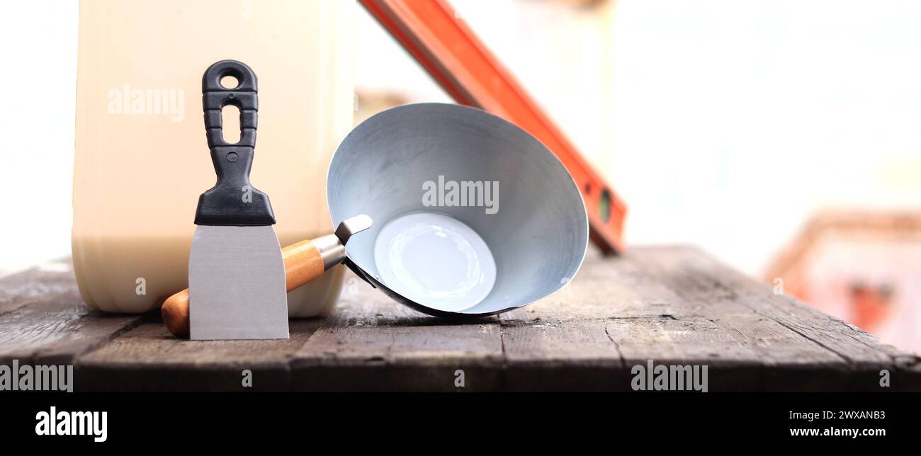 Construction or plastering ladle, a spatula, a construction level and a ...