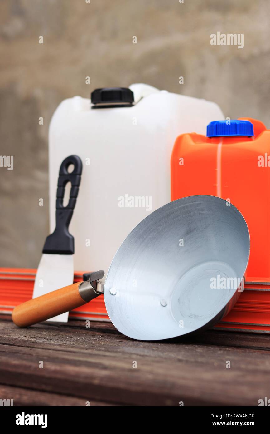 Construction or plastering ladle, a spatula, a construction level and a ...