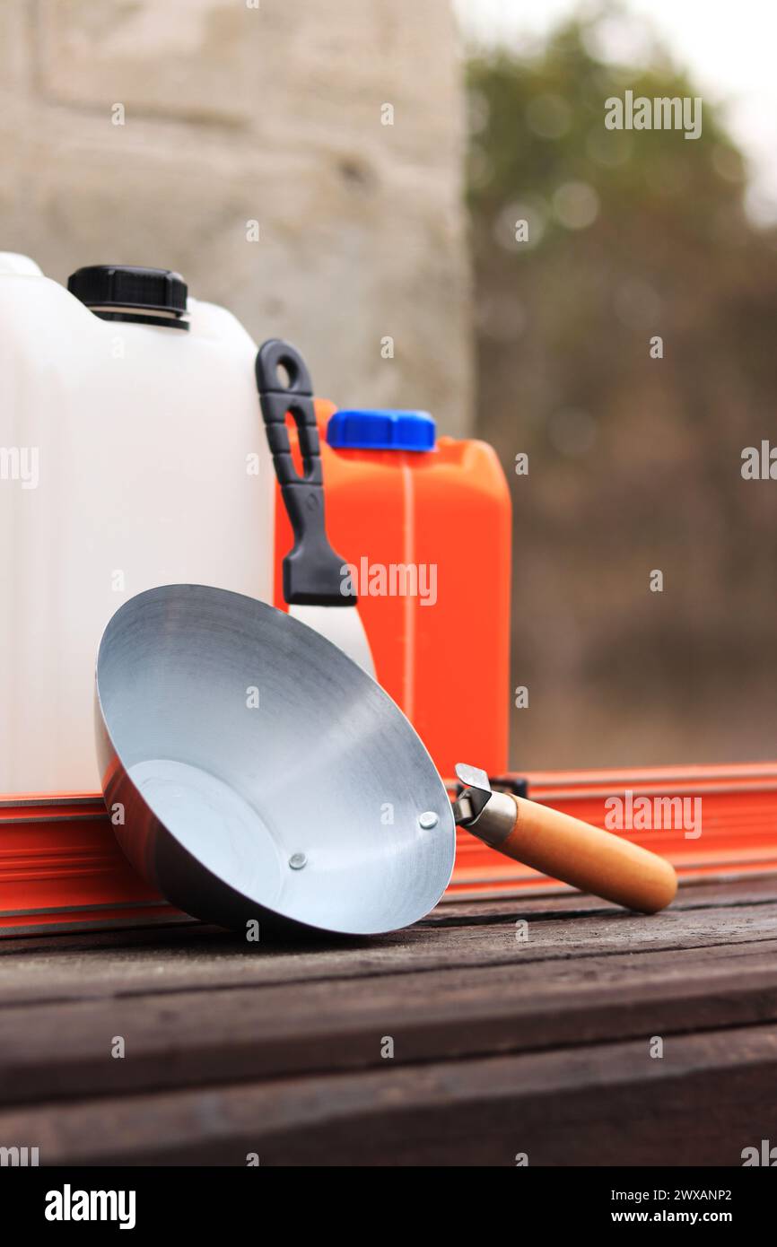 Construction or plastering ladle, a spatula, a construction level and a ...