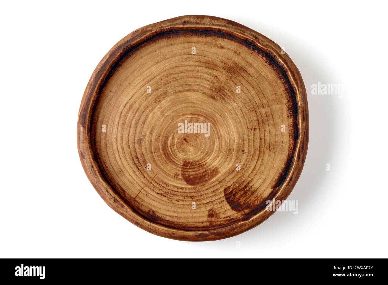 A brown hand carved wooden plate is isolated on a white background. Top ...