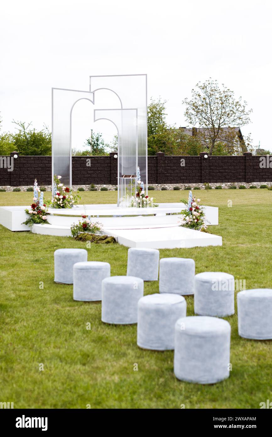 A cluster of white stools arranged neatly on a vibrant green field ...