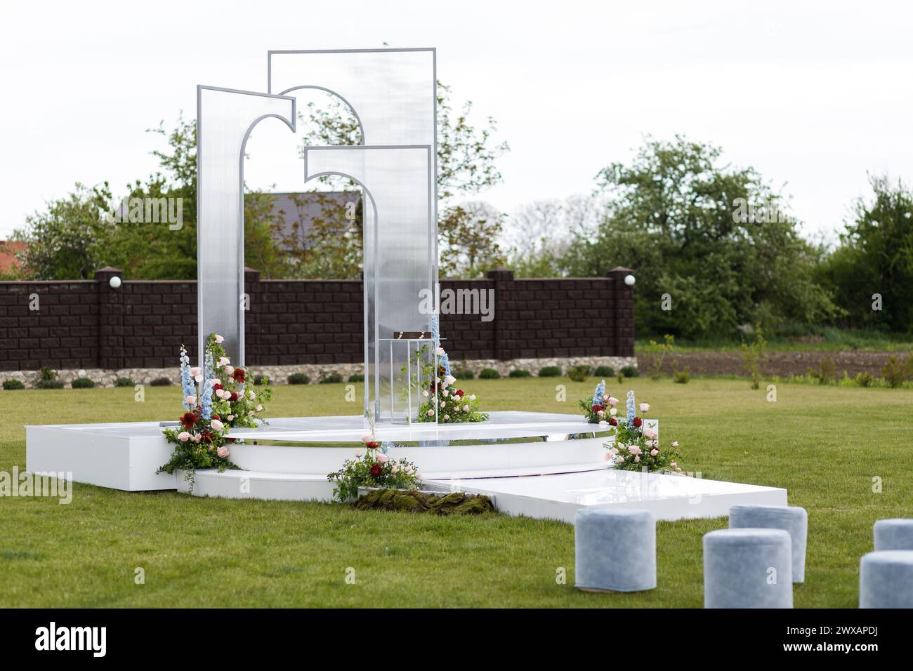 A white monument stands tall in a grassy area, adorned with colorful ...
