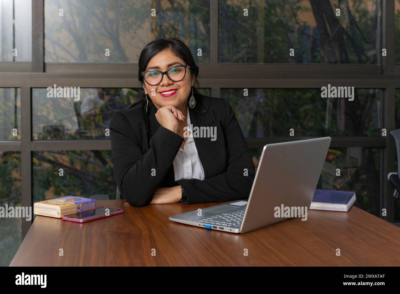Portrait of a Mexican executive woman who is working late at the office ...