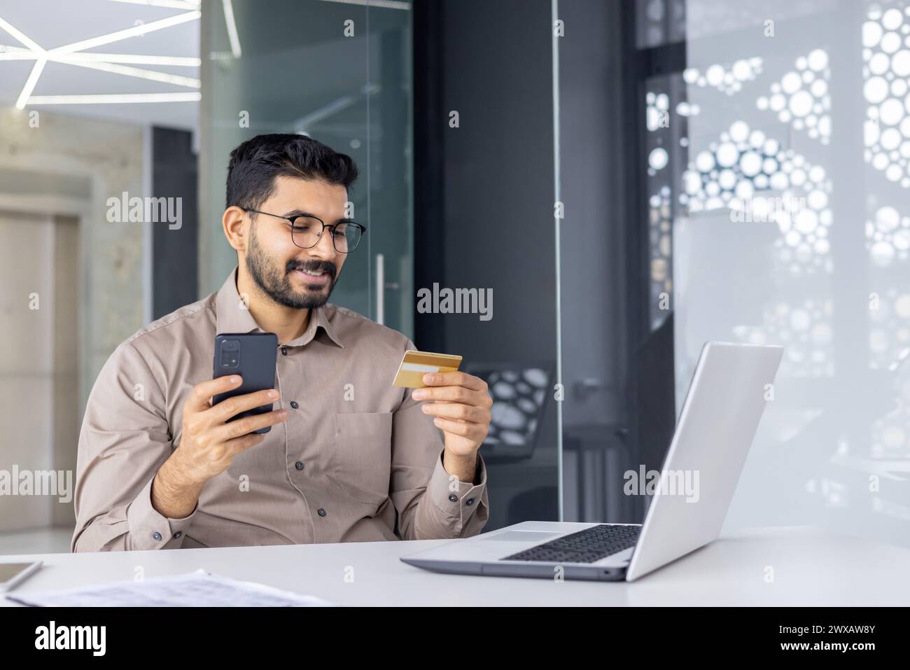 Professional male entrepreneur using smartphone and credit card for ...