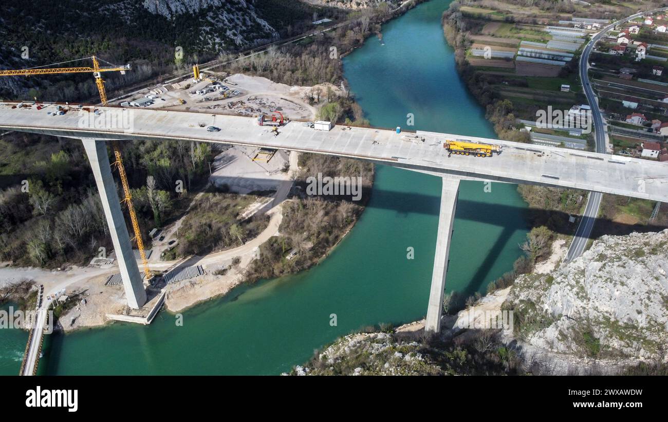 Construction of a high bridge over the river, aerial drone view ...