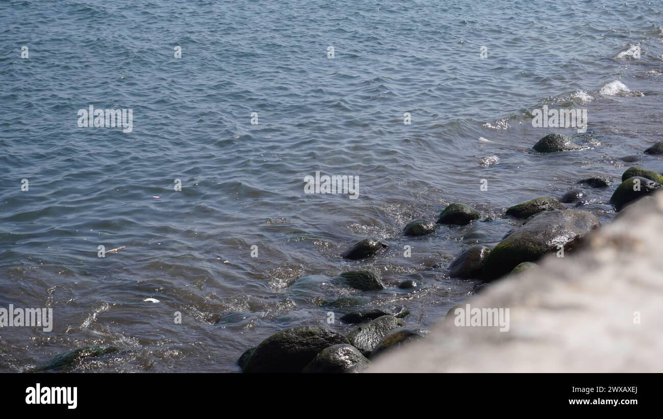 Ocean waves hitting the rocks with overexposure light at beach in ...