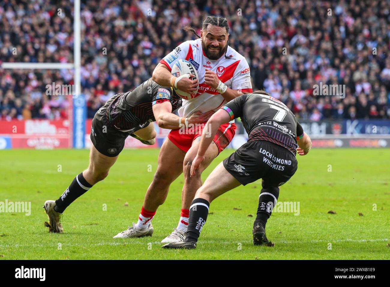 Konrad Hurrell of St. Helens is tackled by Alex Smith of Wigan Warriors ...