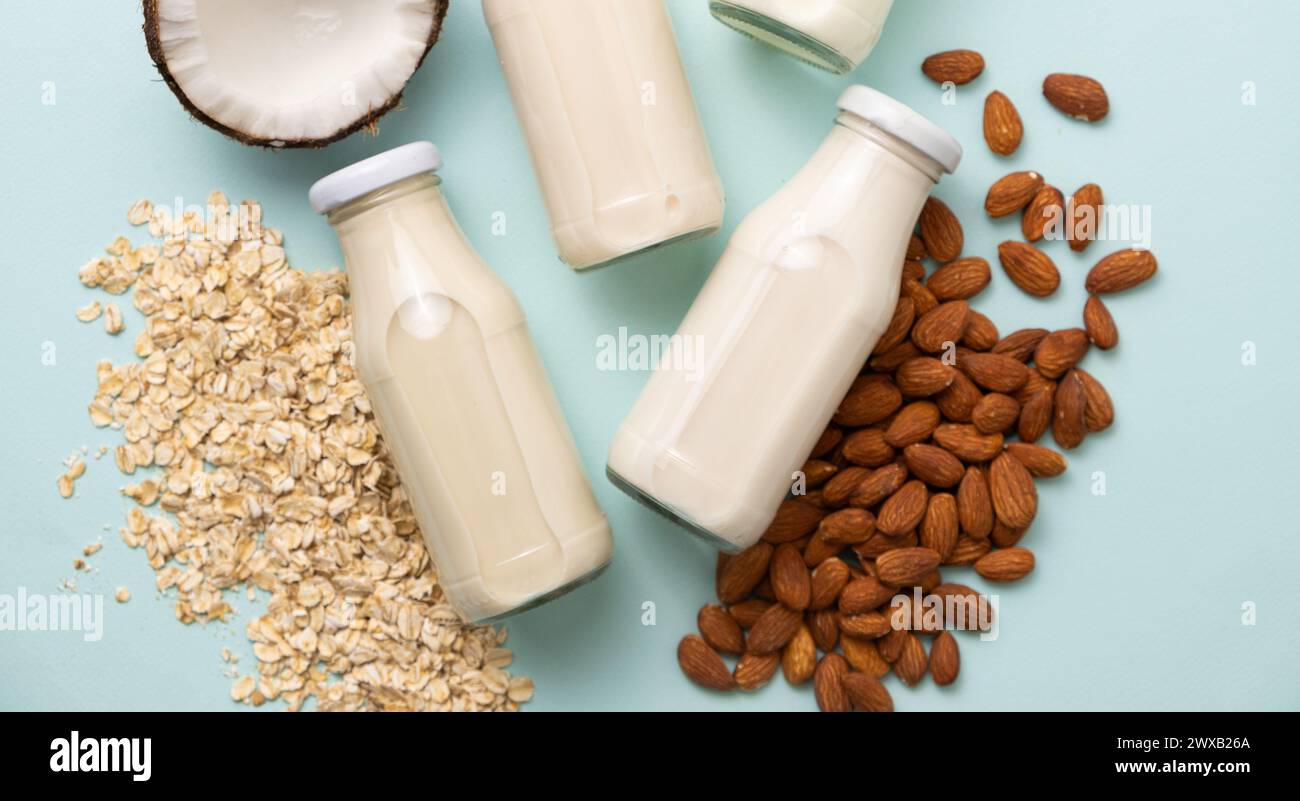 Types of plant-based milk in glass bottles on blue background, top view ...