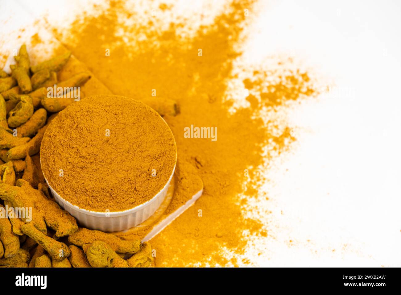 Turmeric powder, spices and dried root on white background. Top view ...