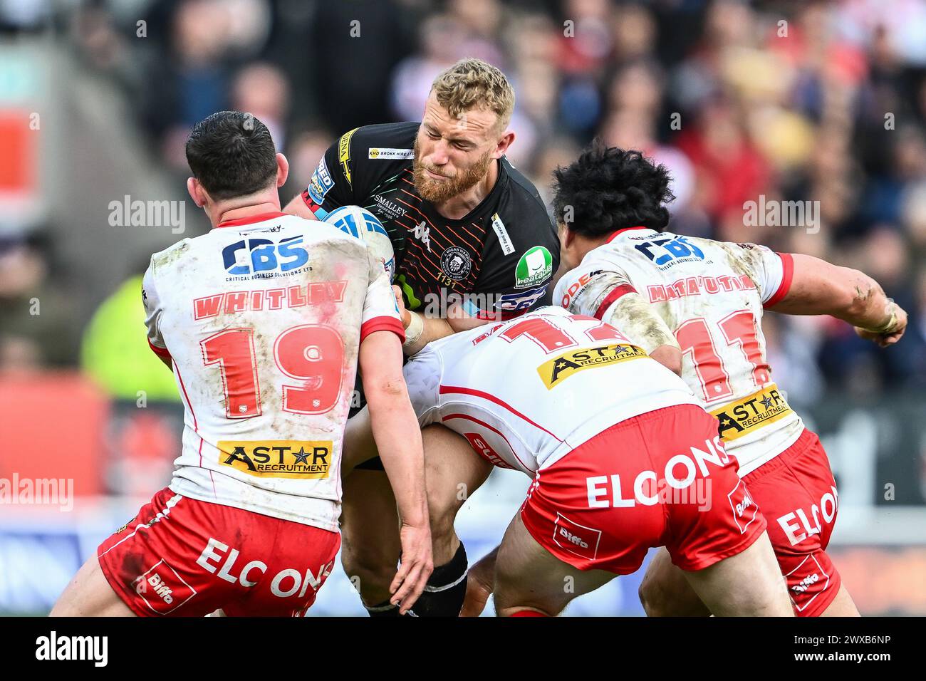 Luke Thompson of Wigan Warriors is tackled by Matt Whitley of St ...