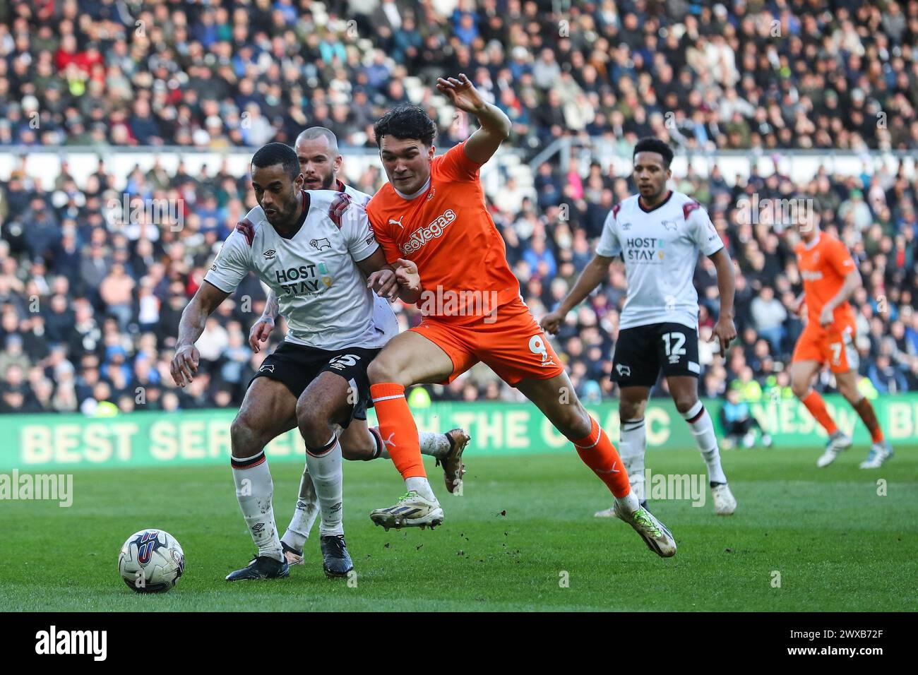Curtis Nelson of Derby County and Kyle Joseph of Blackpool battle for ...