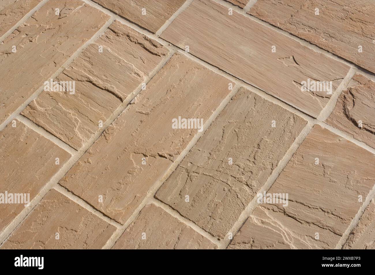 Close-up of quartz sandstone tiles in staggered layout. Beige and tan ...