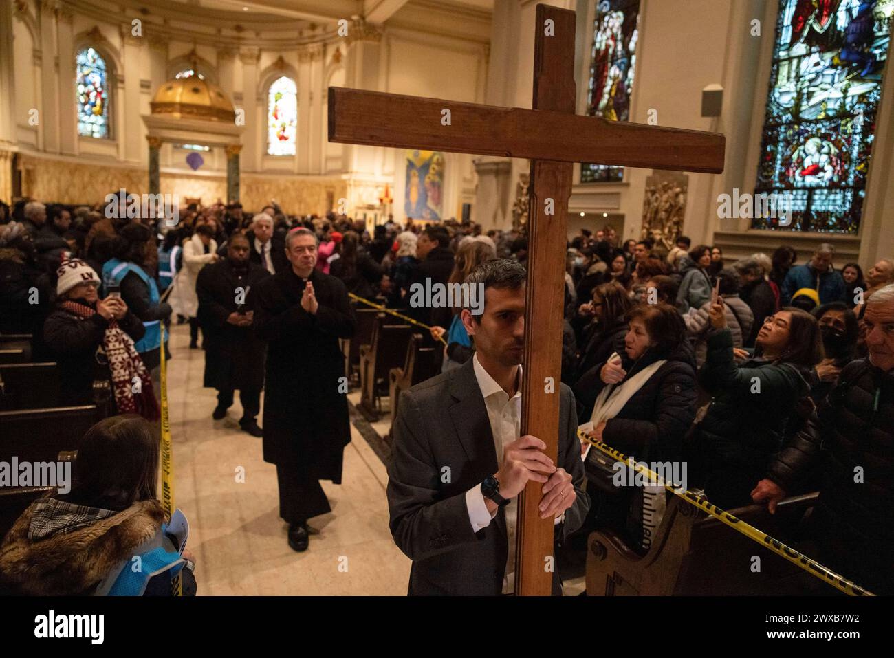 A person carries a cross during a religious procession called the Way ...