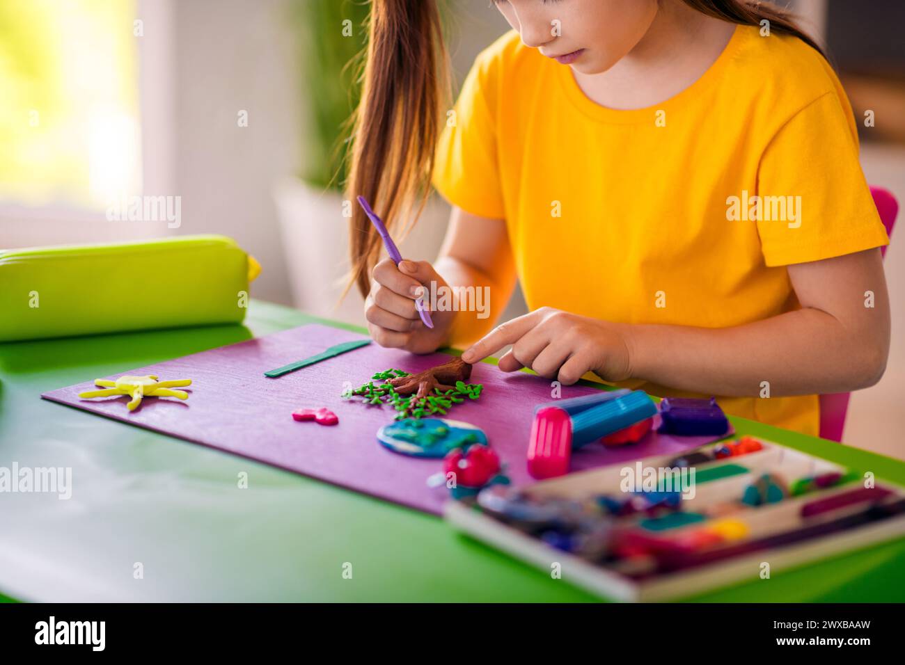 Photo of talented adorable little girl daughter sculpturing plasticine ...