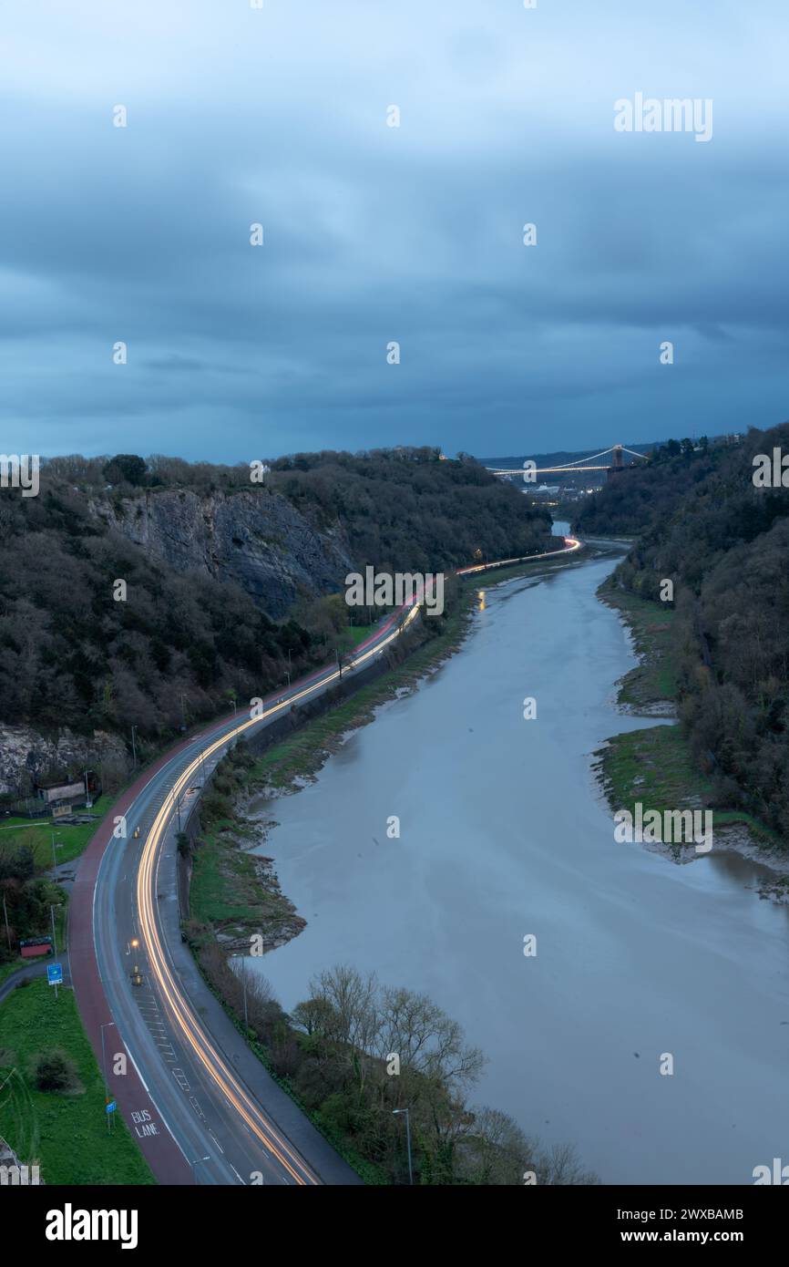Aerial view of a curving road beside a calm river during the blue hour ...