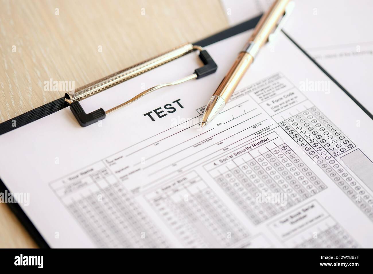 Blank educational test for students lies on table in classroom with pen ...