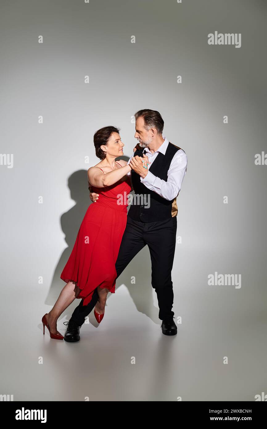 Image of mature couple tango dancers in red dress and suit performing ...