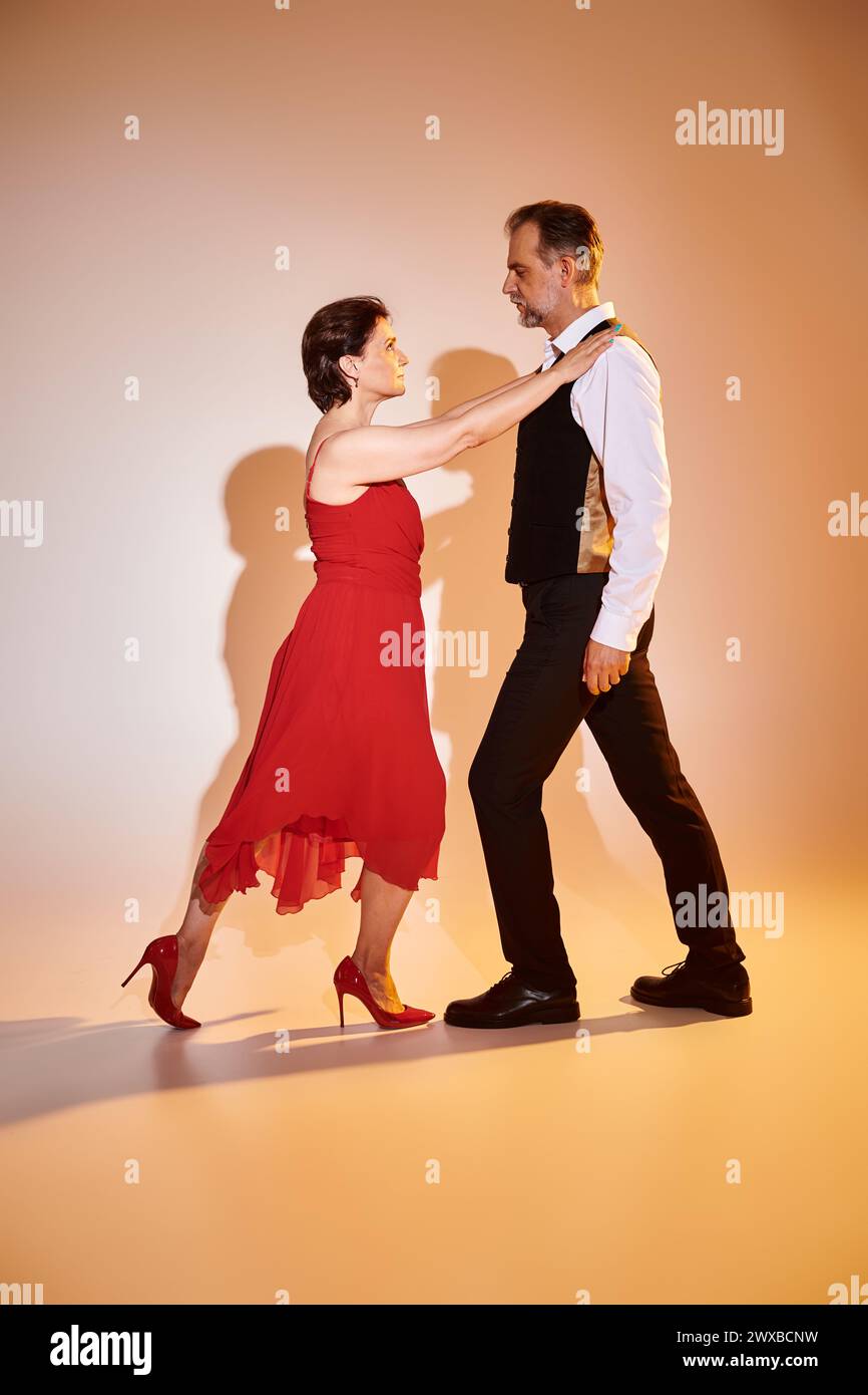 Image of mature couple tango dancers in red dress and suit performing ...