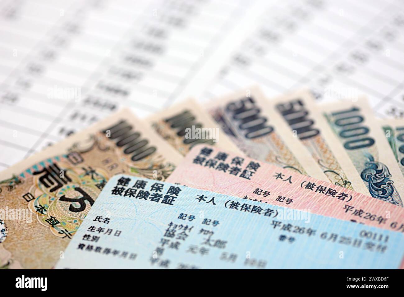 Light blue and red Japan Health Insurance cards on table with japanese ...