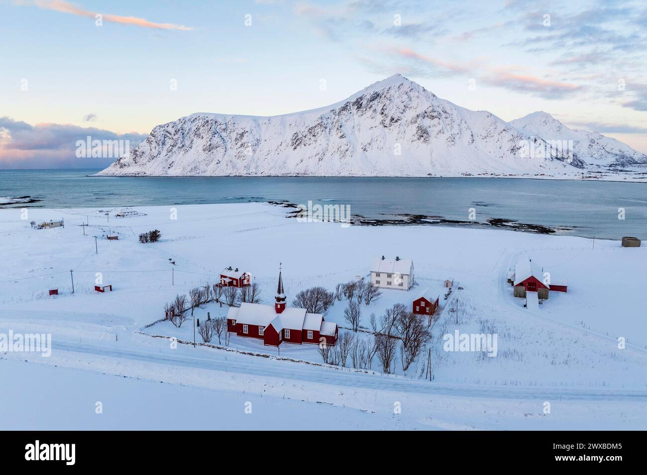 Flakstad church in snowy landscape, mountain and fjord, Lofoten, Norway ...