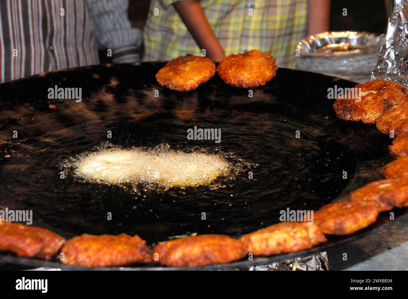 Preparation of wedding food, Agra, Rajasthan, cook deep-frying ...