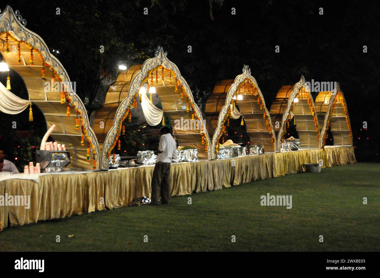 Wedding in India, Outdoor evening buffet with ornamental gold-coloured ...