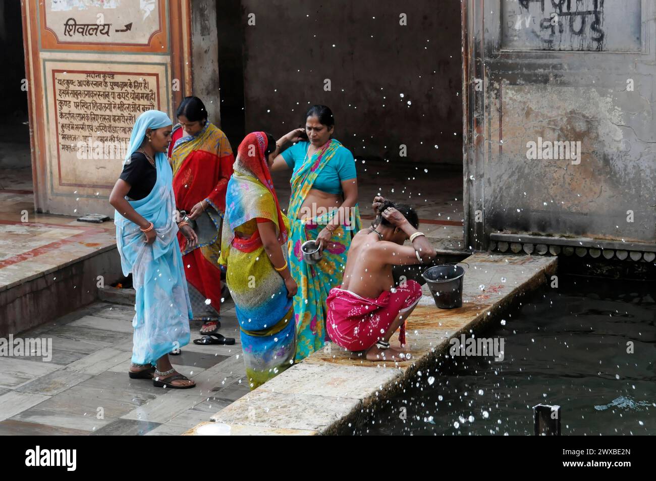 Galta Gorge, woman in colourful saris performing a water ritual at a ...