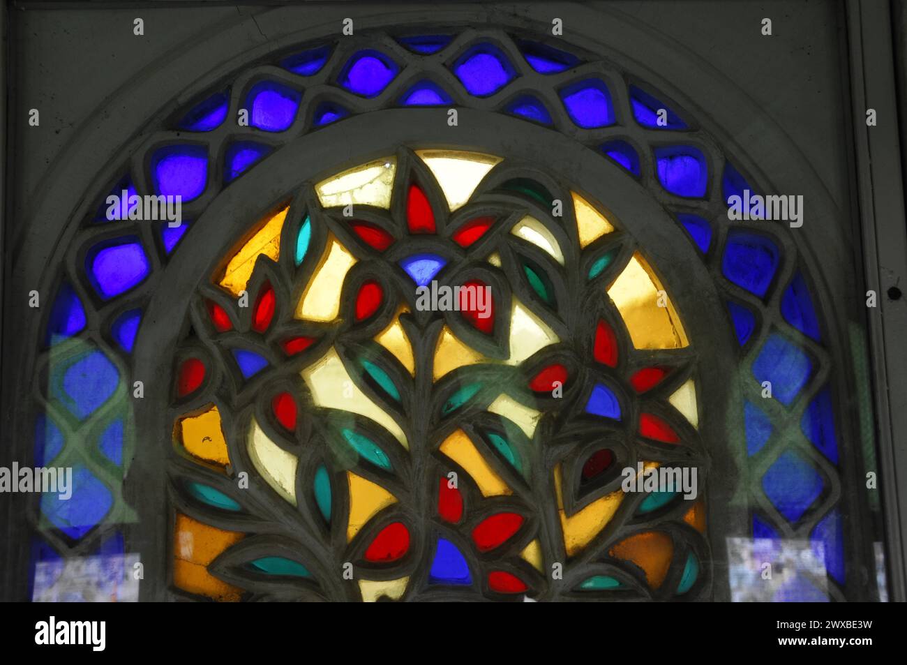 Detail of a colourful and ornamented glass window in a mausoleum ...