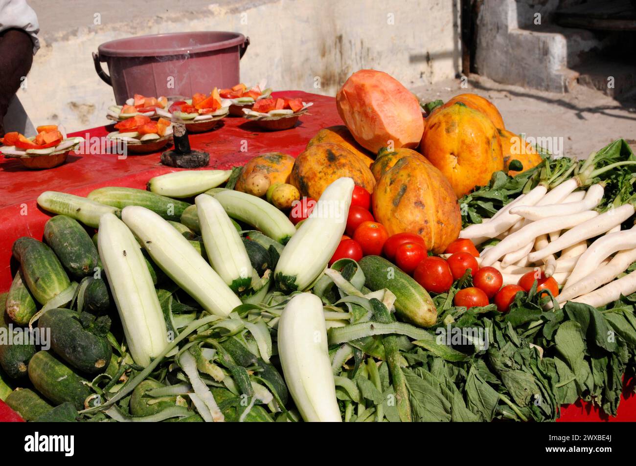 Fresh vegetables presented on a red table at a market stall, Jaipur ...