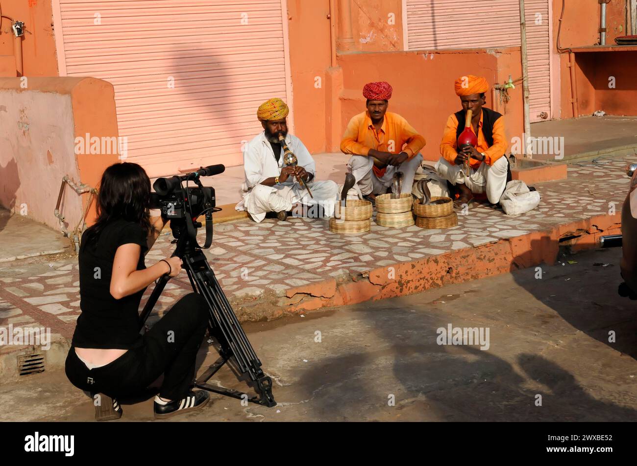 Film crew records musicians in traditional dress at a street concert ...