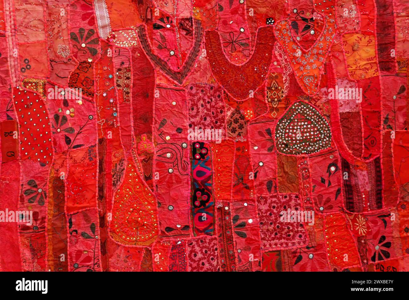 Red textile artwork with complex patterns and decorations, Jaipur ...