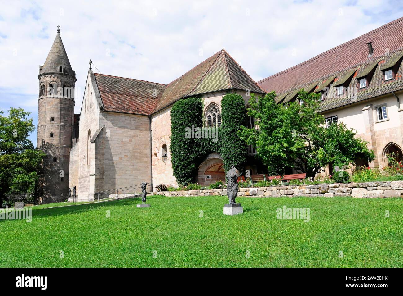 Exterior view of a medieval church with sculptures in the front garden ...
