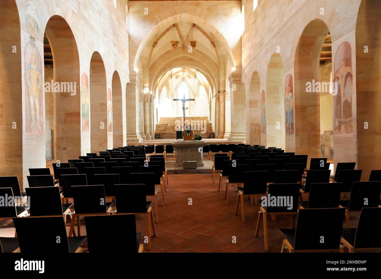 Church interior with wooden benches, a crucifix in the background and a ...