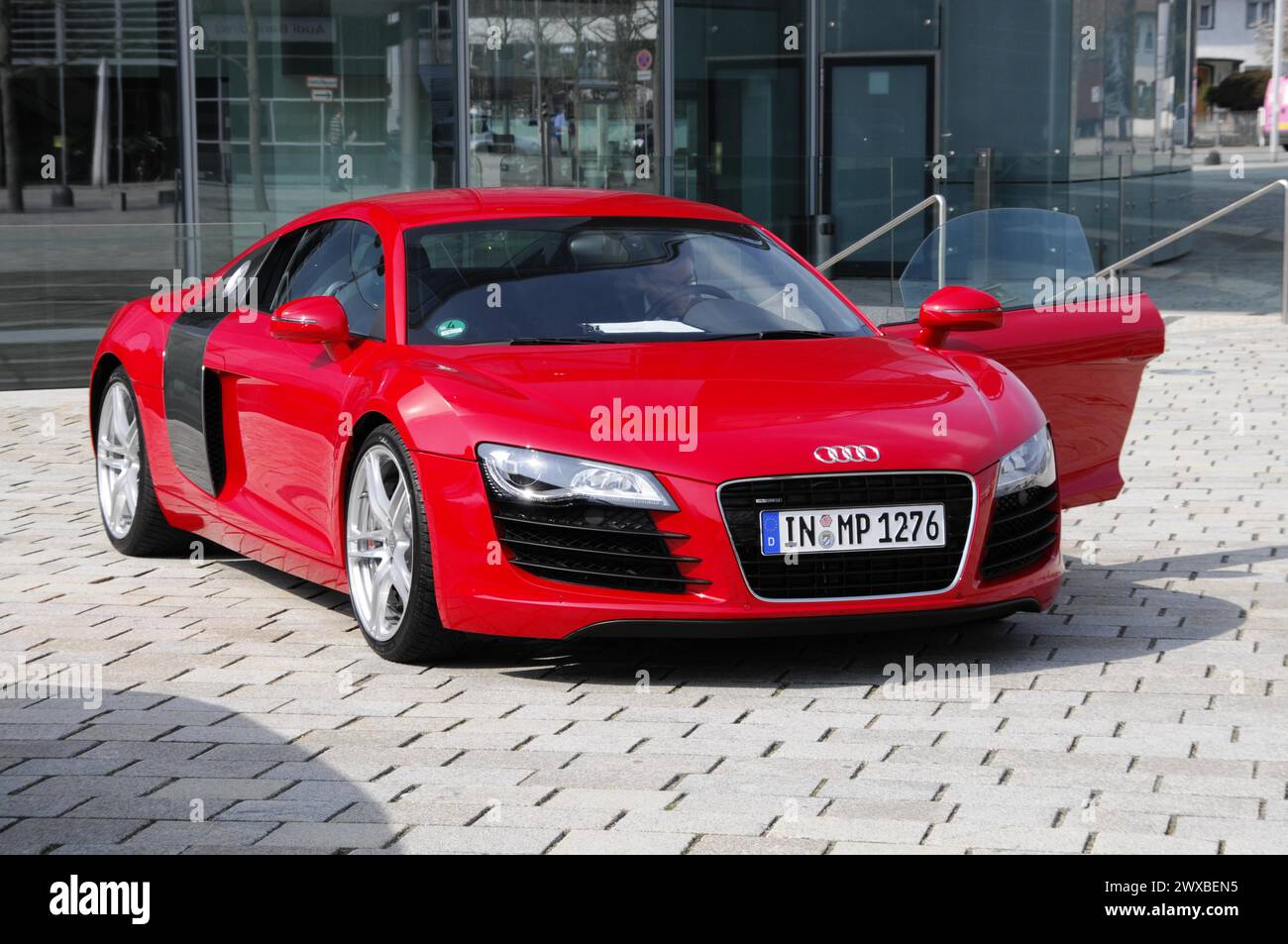 A red Audi R8 sports car parked in front of a modern building, Museum ...