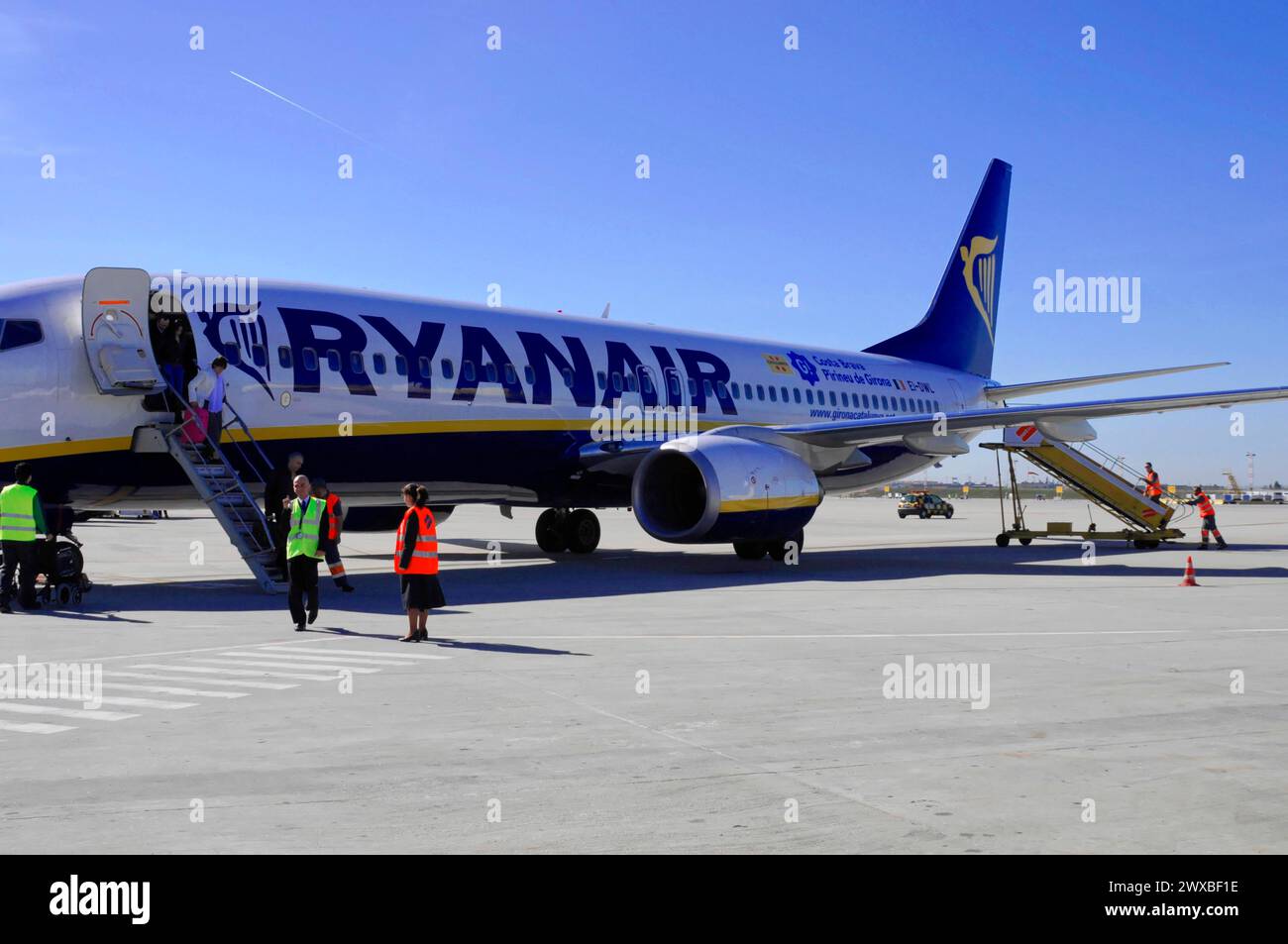 Ryanair aircraft on the tarmac with ground crew and passenger boarding ...