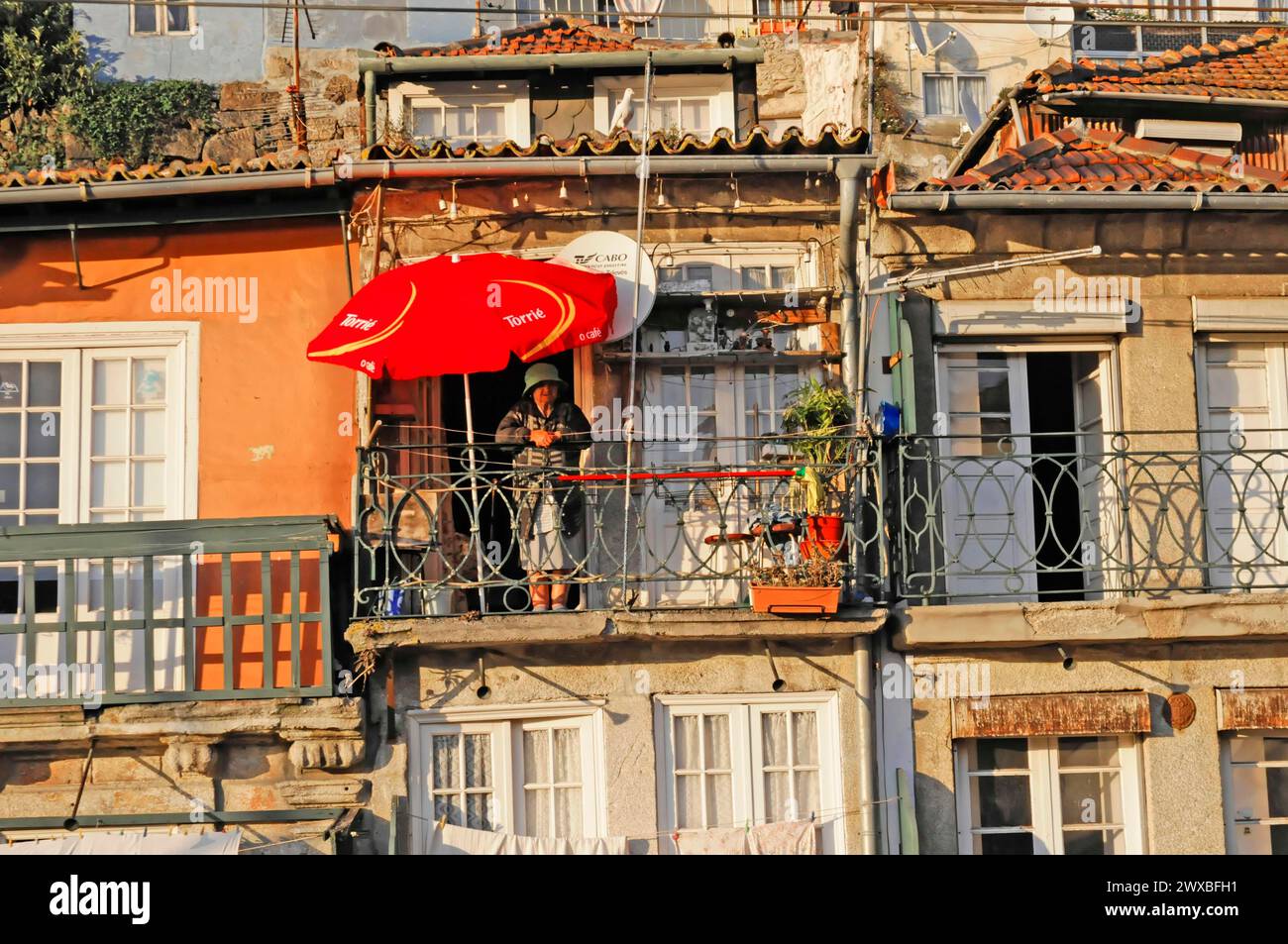 Person on a residential balcony under a parasol in everyday life, Porto ...