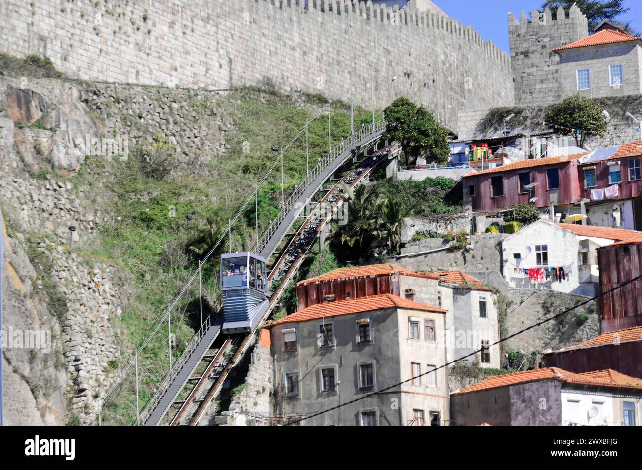 Old town Porto, city cable car runs along buildings on a steep incline ...
